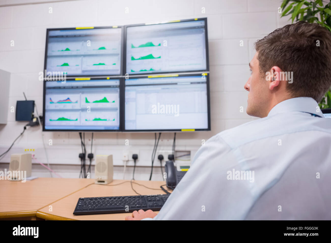 Serious technician looking at computer screen Stock Photo - Alamy