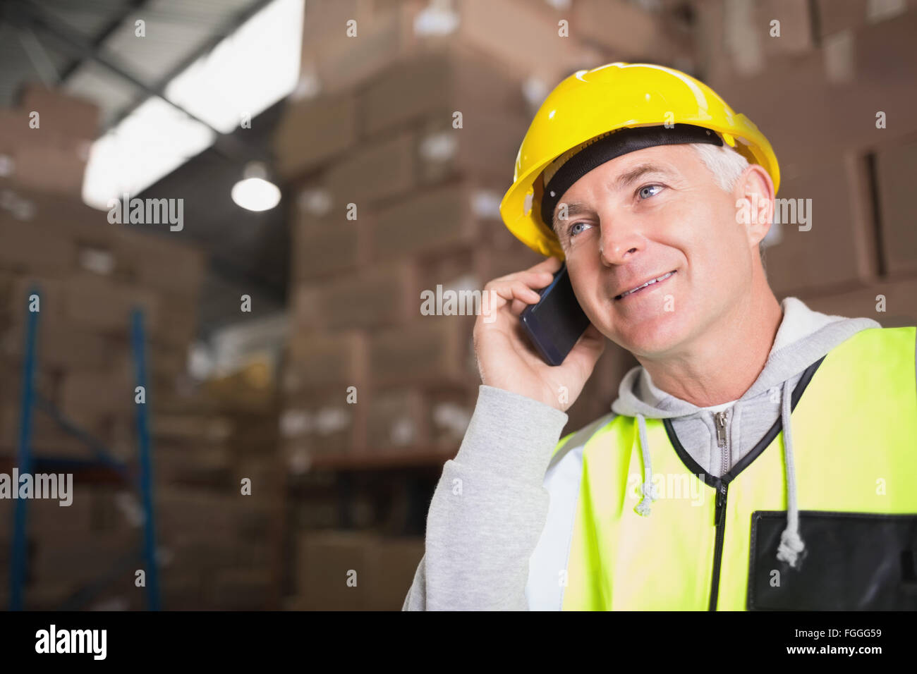 Worker using mobile phone in warehouse Stock Photo - Alamy
