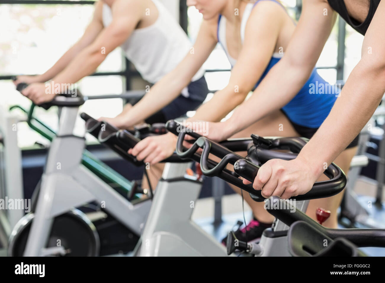 Fit group of people using exercise bike together Stock Photo - Alamy