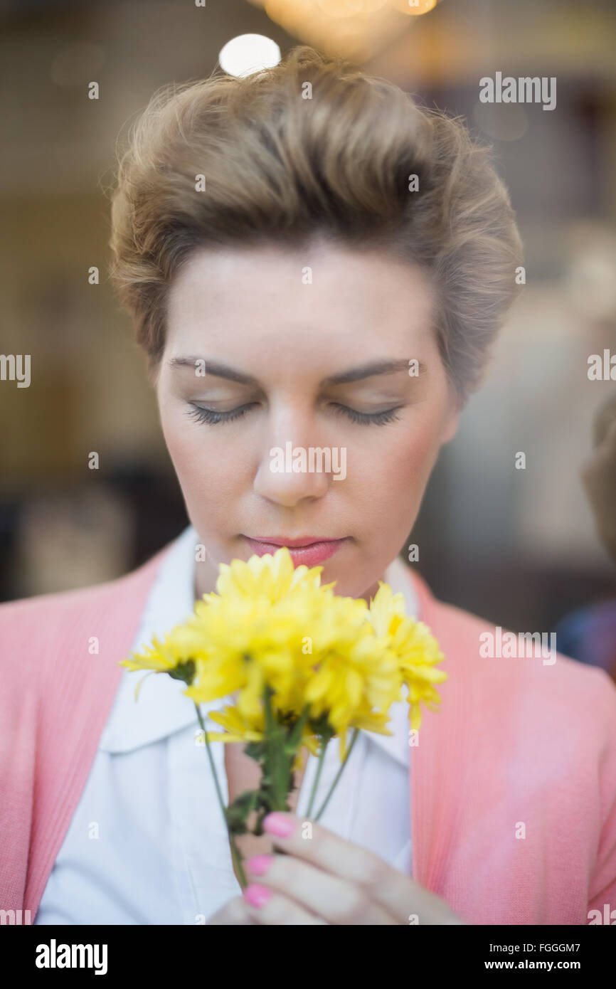 Pretty blonde smelling yellow flowers Stock Photo - Alamy