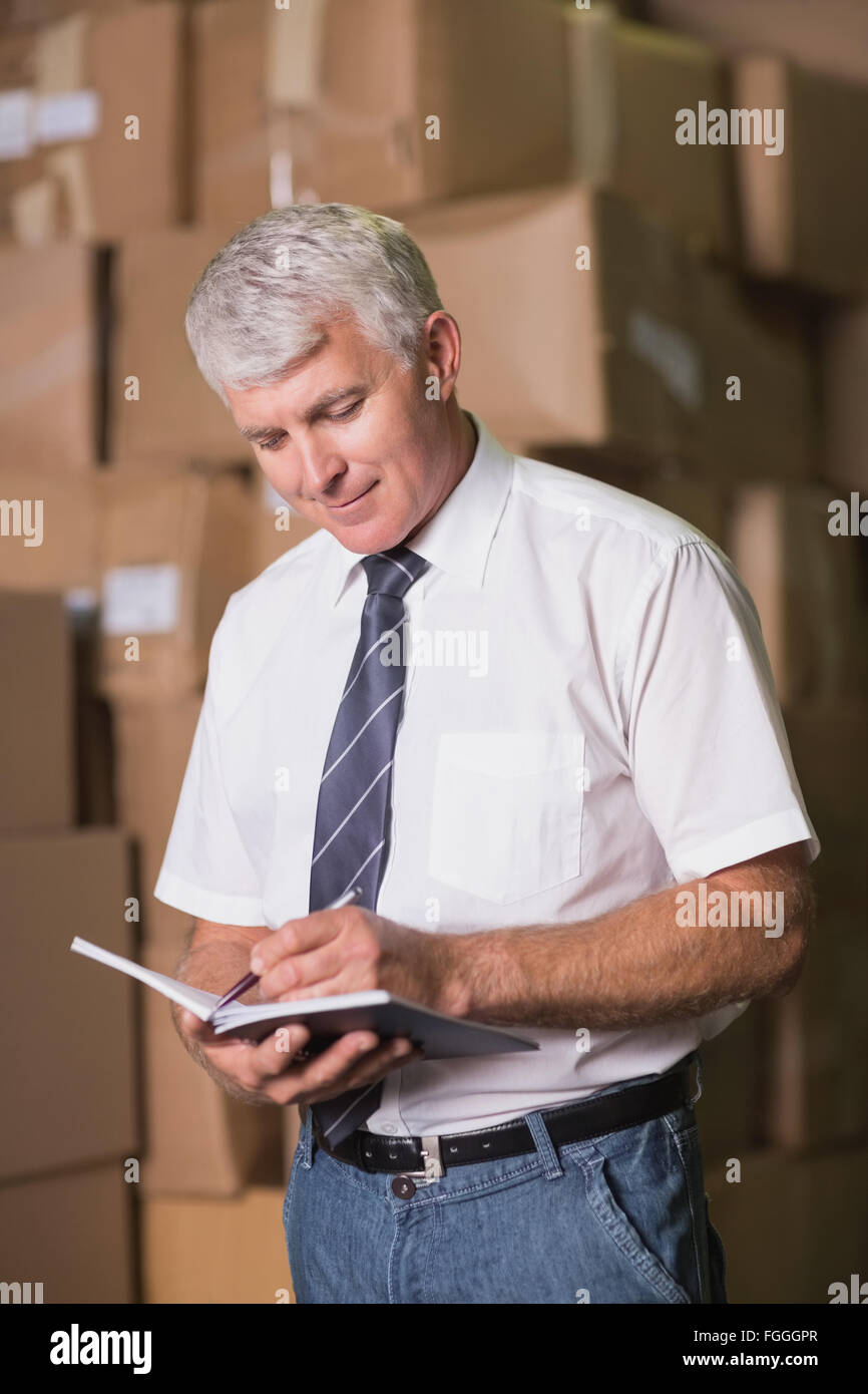 Manager with diary in warehouse Stock Photo - Alamy