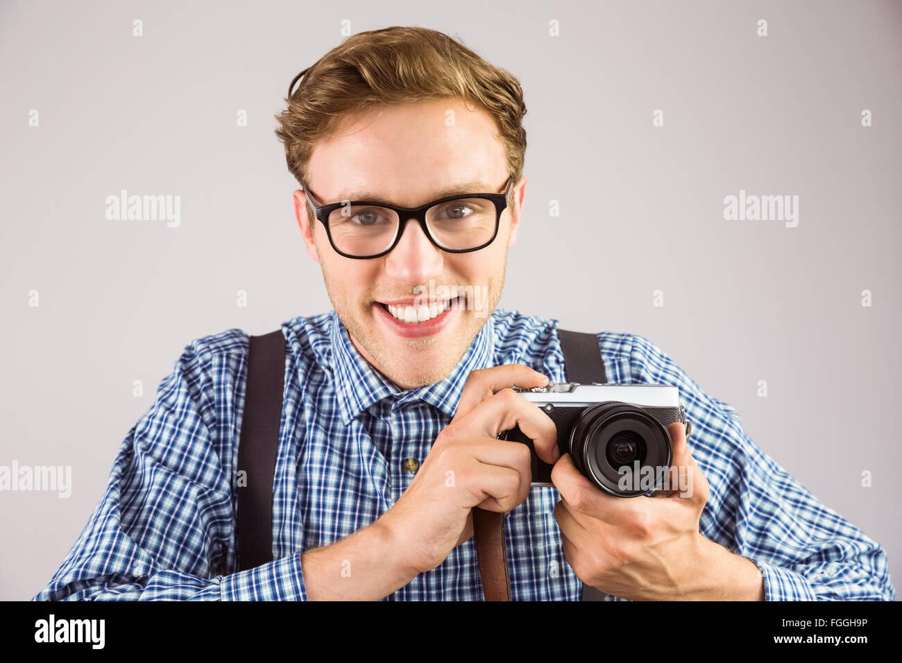Geeky hipster holding a retro camera Stock Photo - Alamy