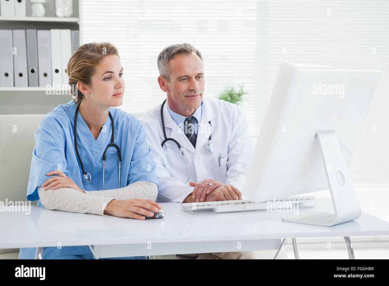 Medical workers looking at a computer Stock Photo - Alamy