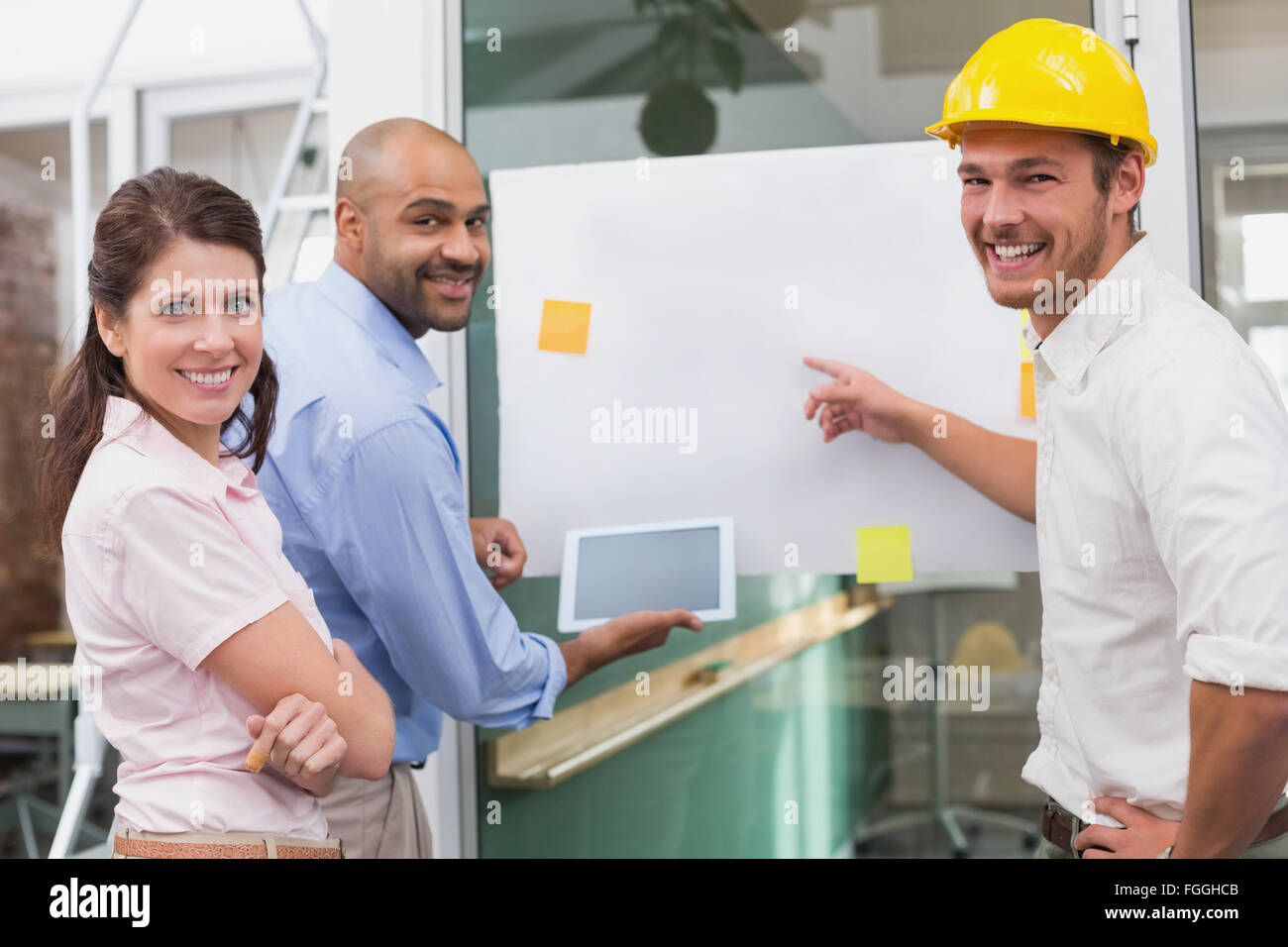Smiling architect team brainstorming together using tablet Stock Photo ...