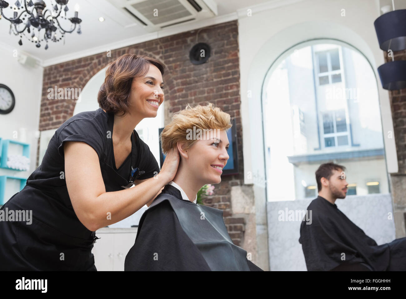 Smiling hairdresser chatting with customer Stock Photo - Alamy
