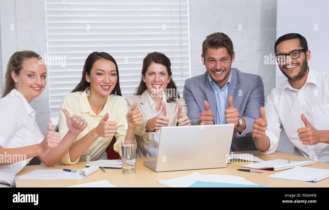 Business team smiling at camera showing thumbs up Stock Photo - Alamy