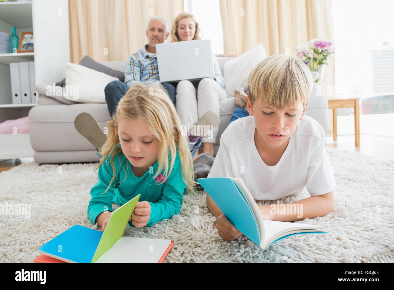 Siblings reading books on the floor Stock Photo - Alamy