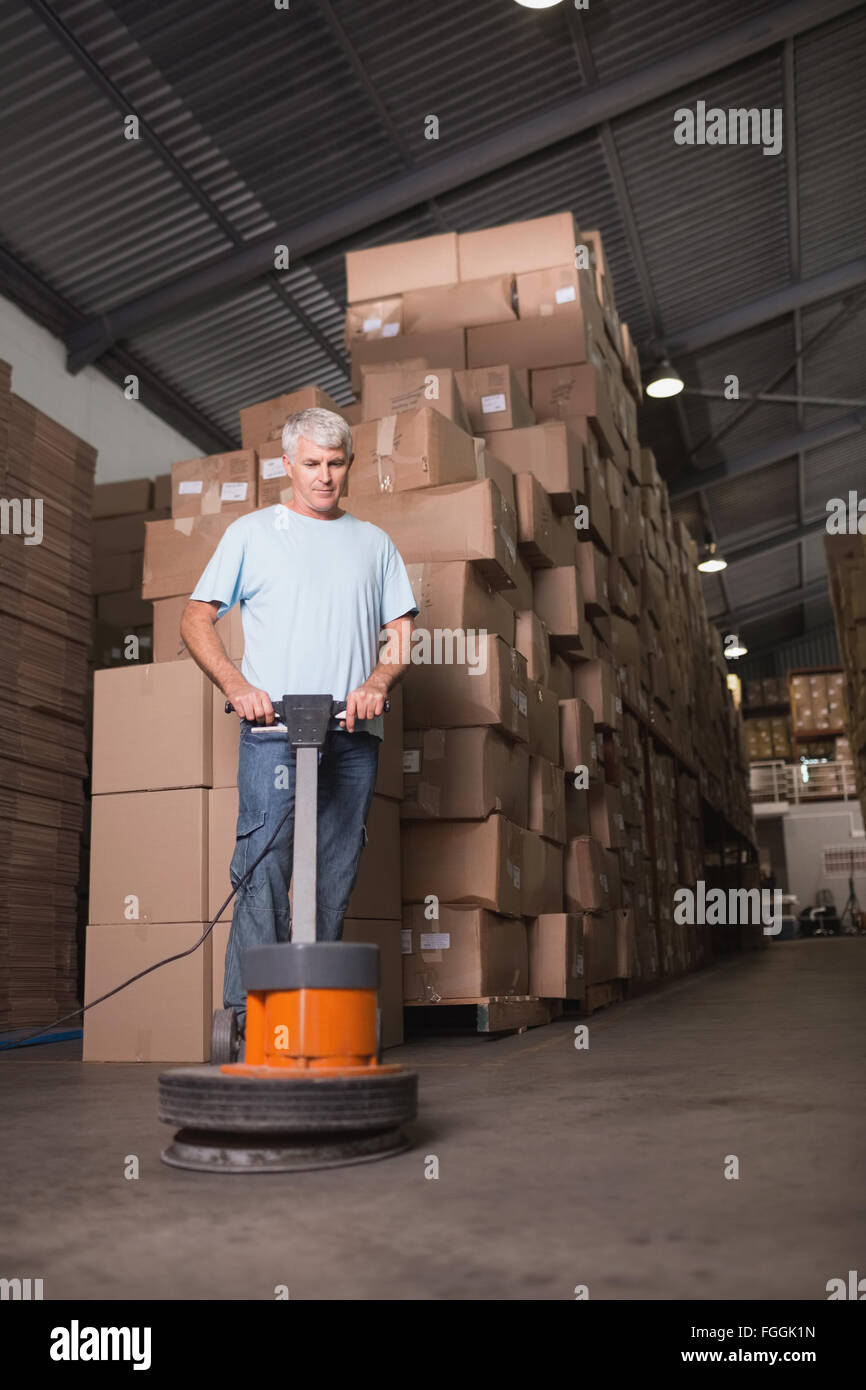 Man cleaning warehouse floor with machine Stock Photo - Alamy