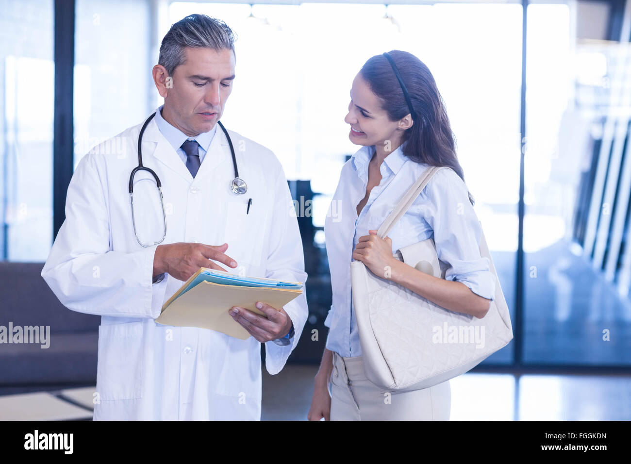 Doctor looking at medical report Stock Photo - Alamy
