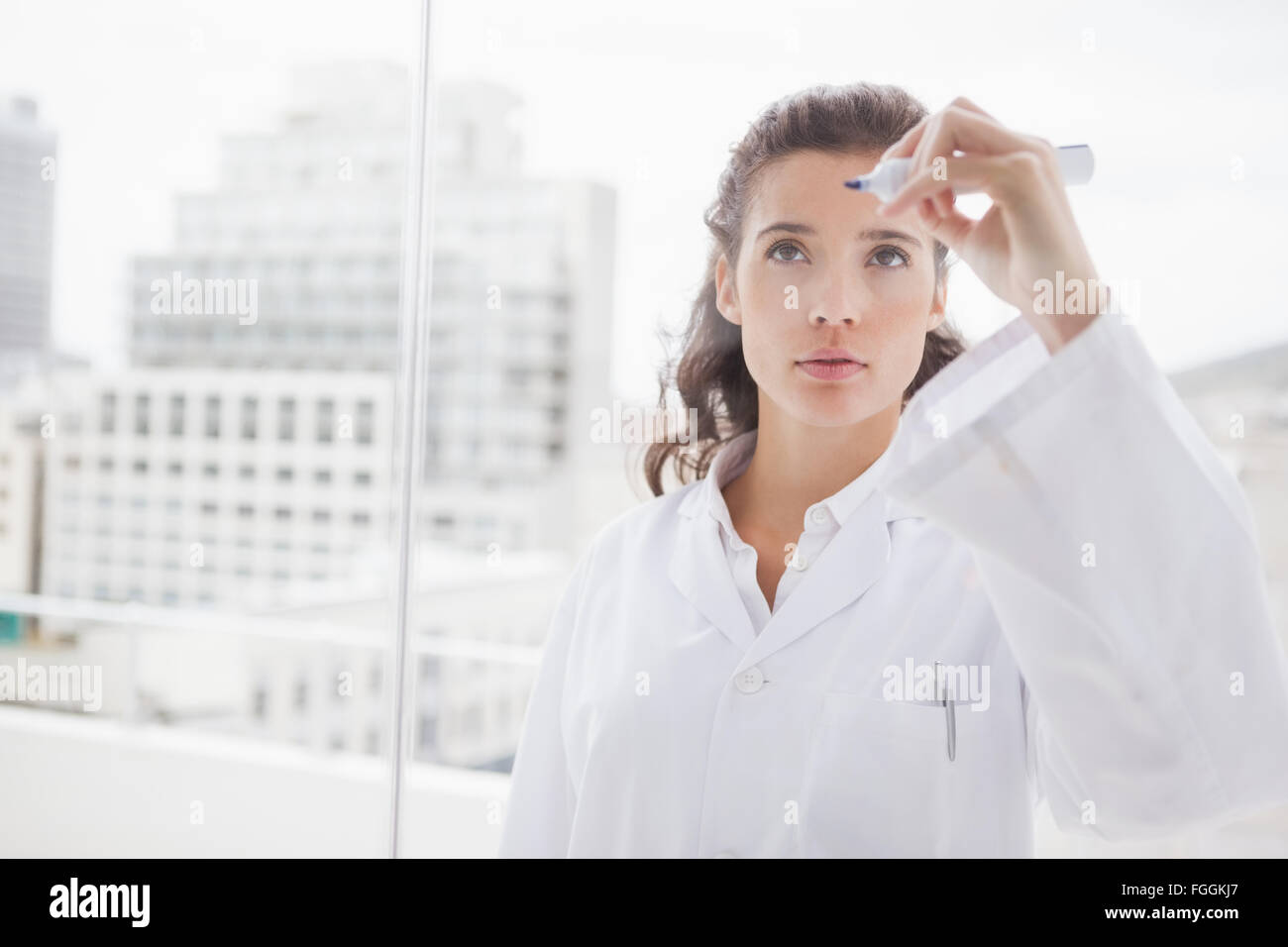 Concentrated doctor writing on the board Stock Photo - Alamy