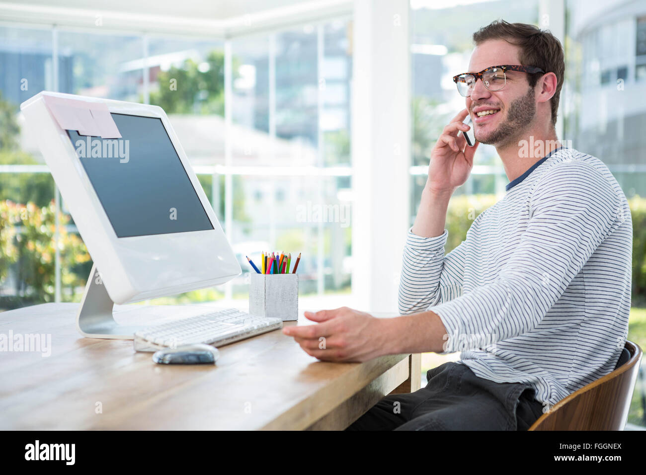 Handsome man working on computer and on the phone Stock Photo - Alamy