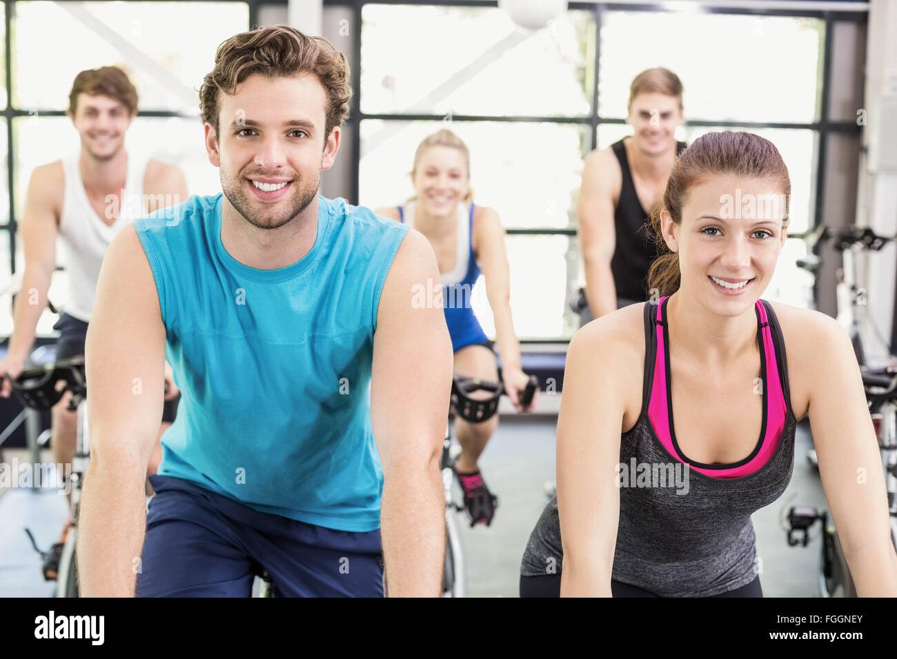 Fit group of people using exercise bike together Stock Photo - Alamy