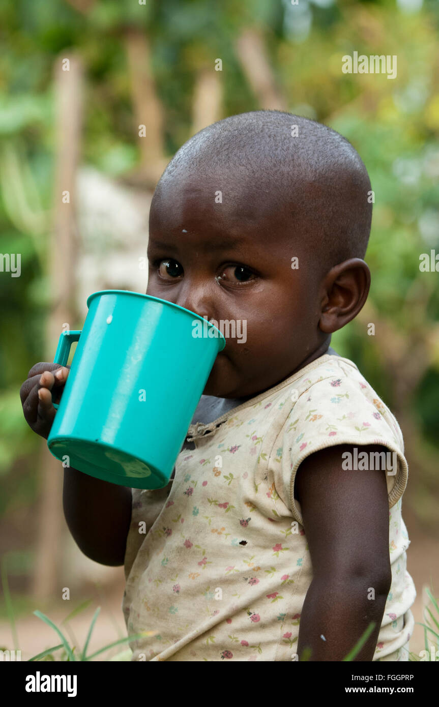 Young child drinking fresh milk from a cup. Uganda Stock Photo - Alamy