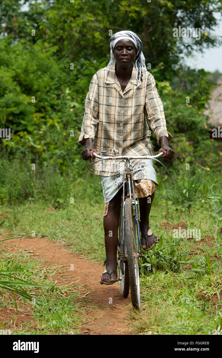 Lady in rural area riding a bicycle along track Stock Photo - Alamy