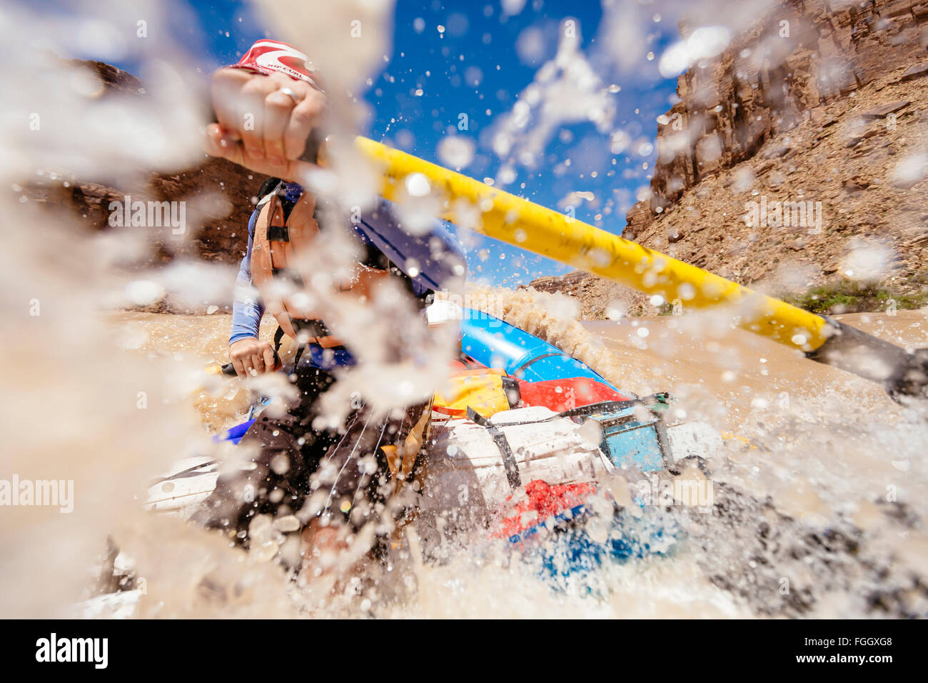A man is rowing a raft through a rapid on the Colorado River Stock ...