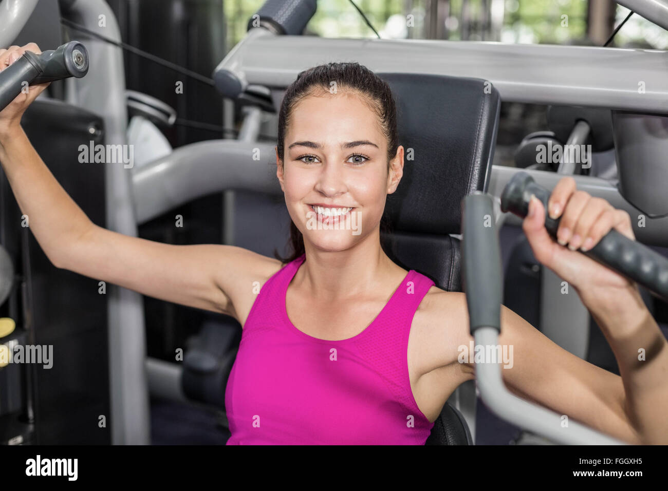 Fit woman using weight machine Stock Photo - Alamy
