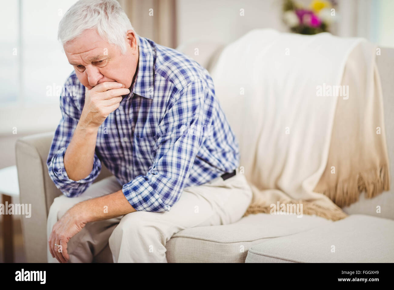 Worried senior man sitting on sofa Stock Photo - Alamy