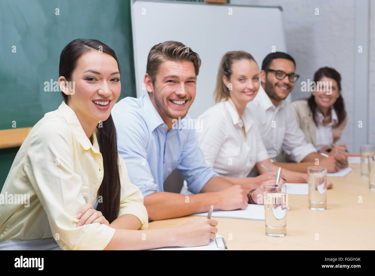 Smiling business people taking notes at a presentation Stock Photo - Alamy
