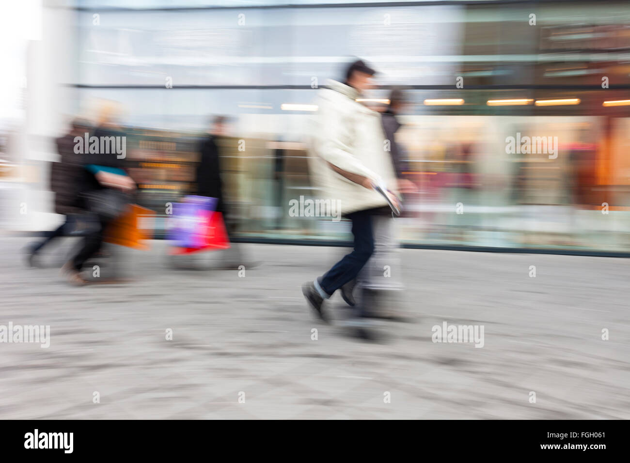 A shopper walking against shop window Stock Photo - Alamy