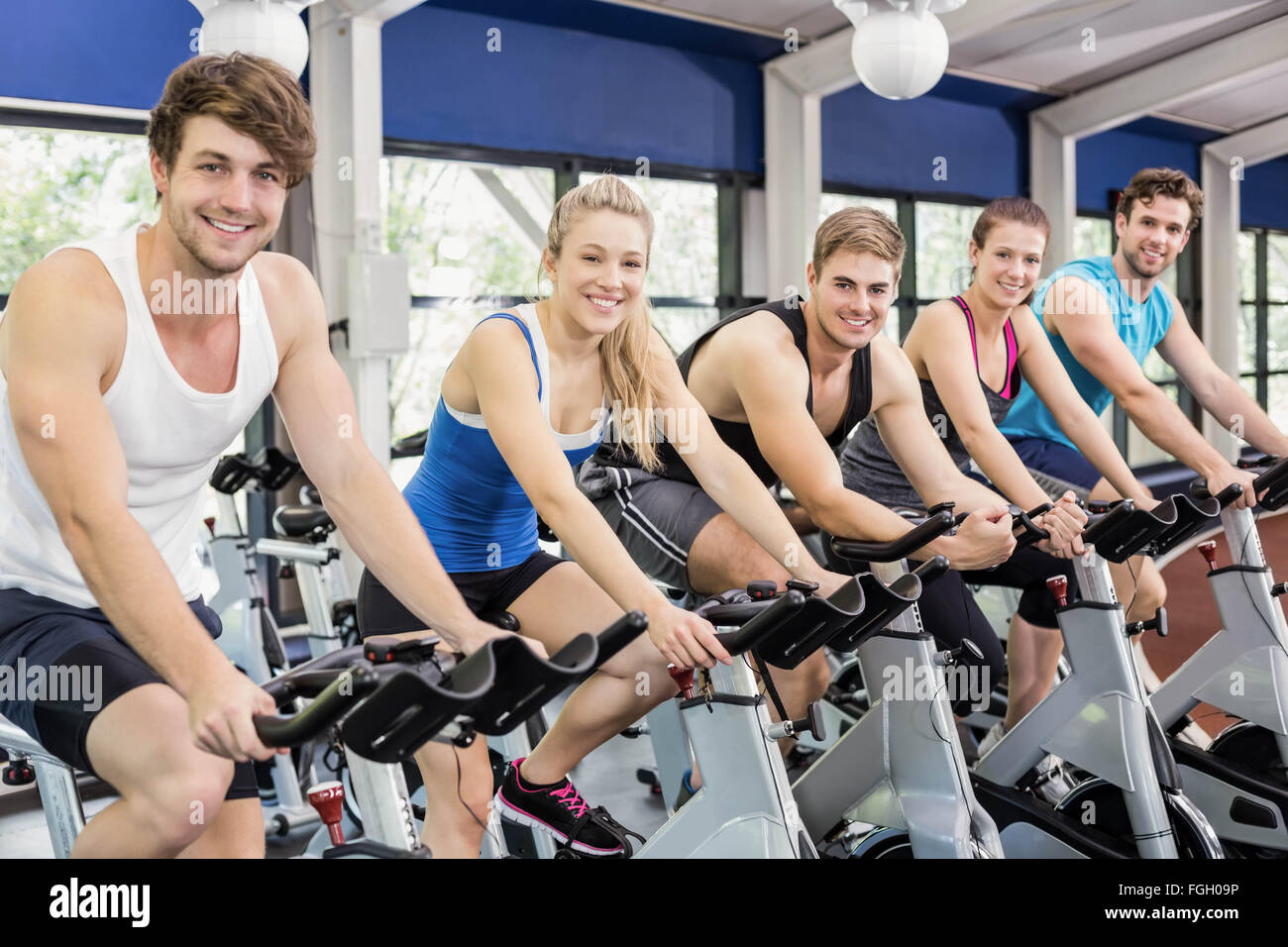 Fit group of people using exercise bike together Stock Photo - Alamy