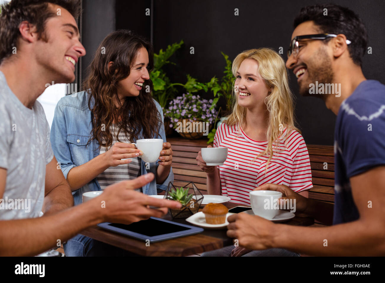 Smiling friends enjoying coffee together Stock Photo - Alamy