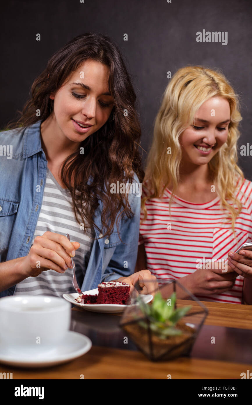 Smiling brunette enjoying a pastry Stock Photo - Alamy