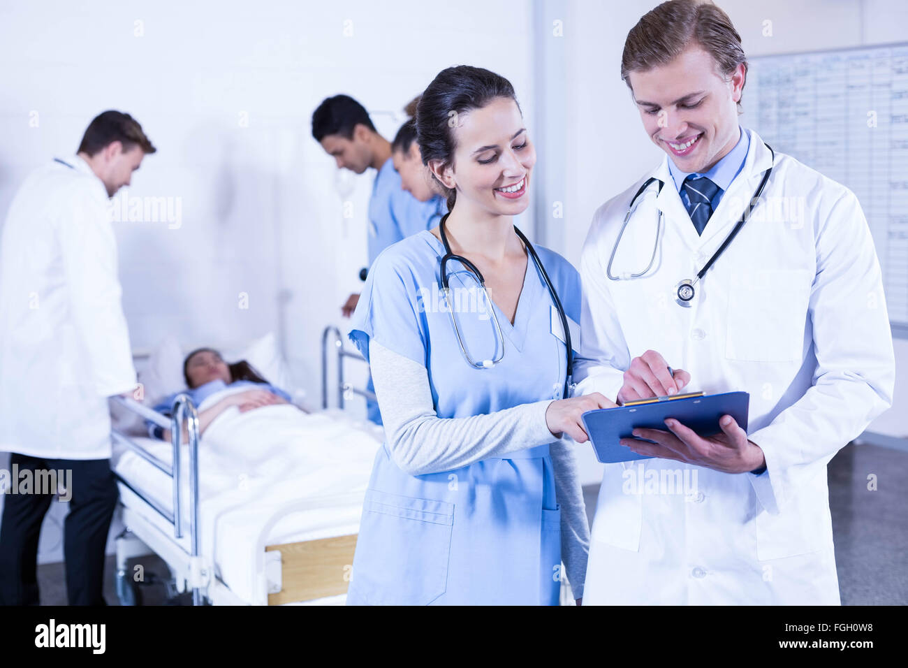 Doctor discussing paperwork on clipboard Stock Photo - Alamy