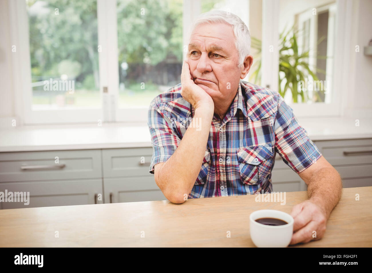 Thoughtful senior man sitting at table Stock Photo - Alamy