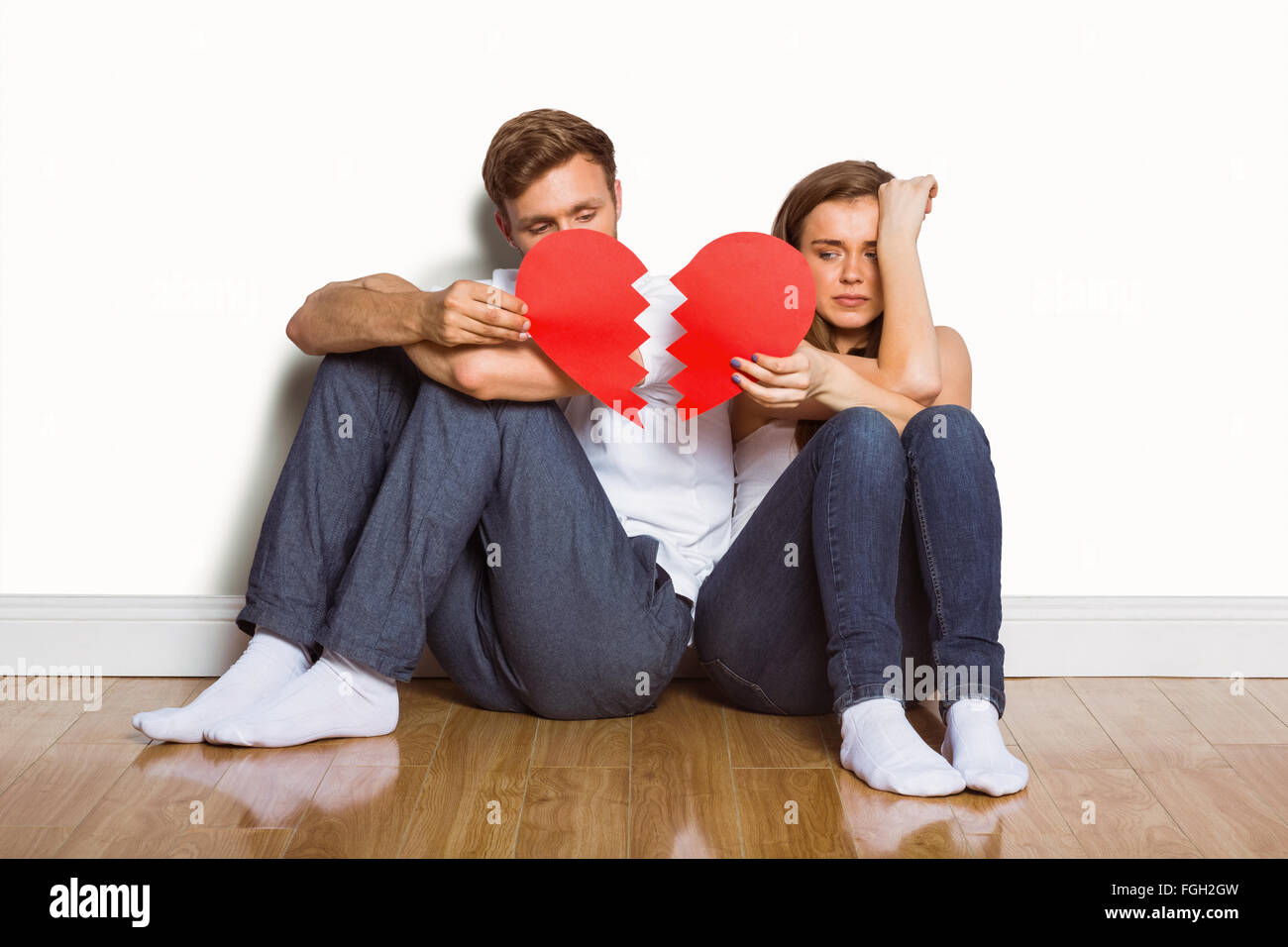 Young couple holding broken heart Stock Photo - Alamy
