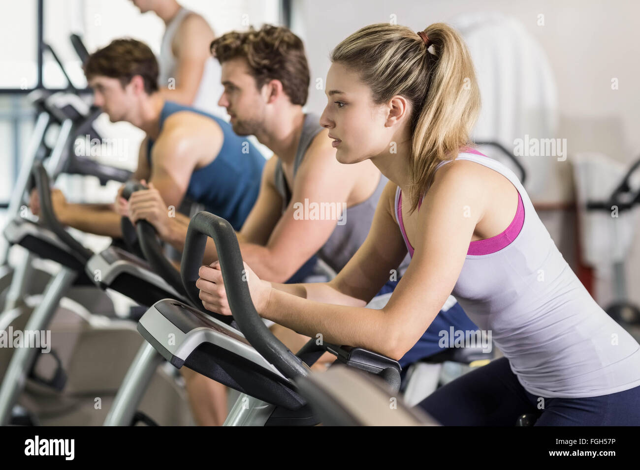 Fit people doing exercise bike Stock Photo - Alamy