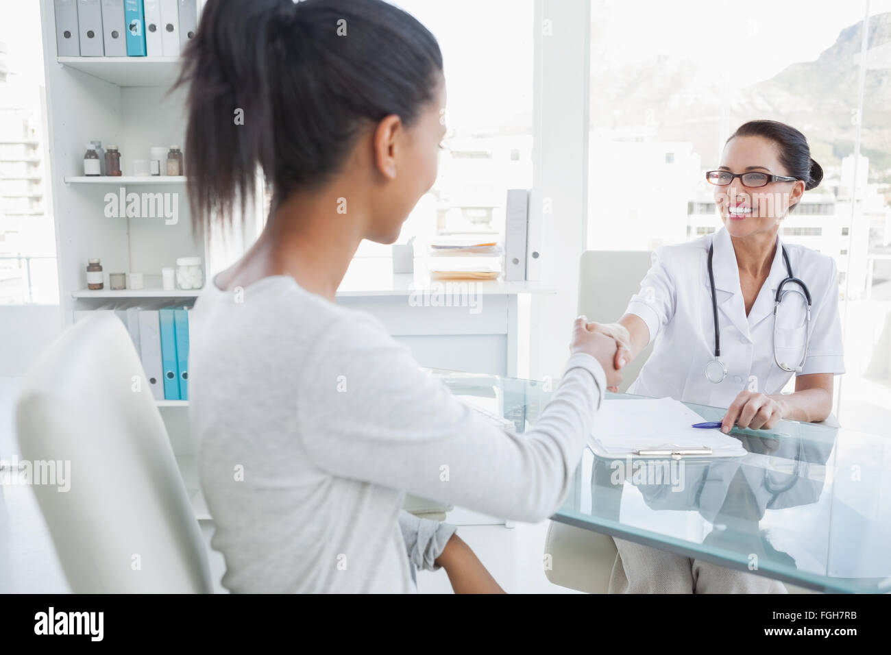 Smiling doctor shaking patients hand Stock Photo - Alamy