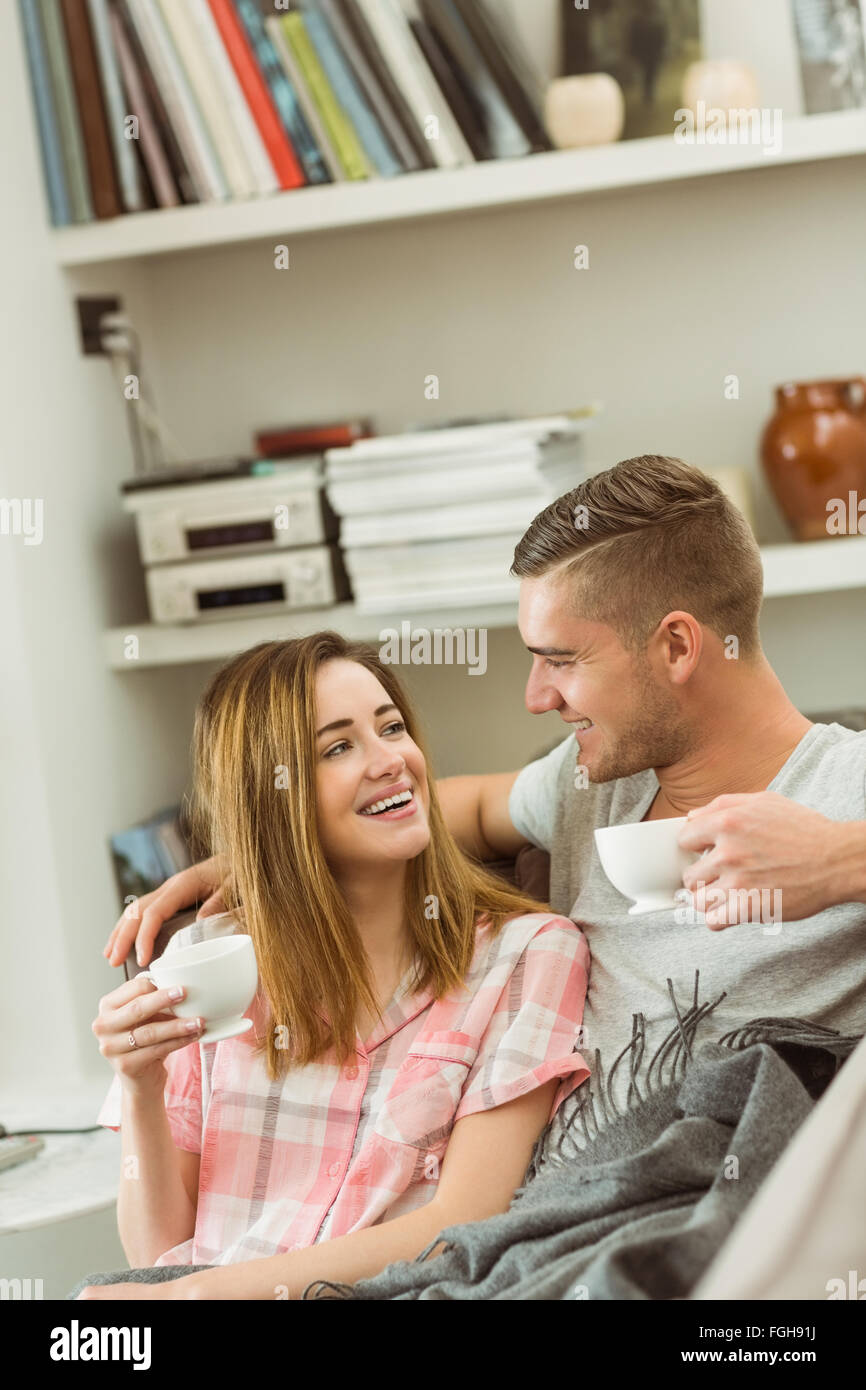 Cute couple relaxing on couch with coffee Stock Photo - Alamy