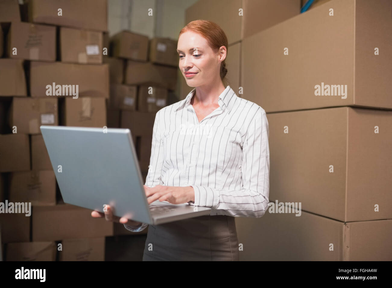 Manager using laptop in warehouse Stock Photo - Alamy
