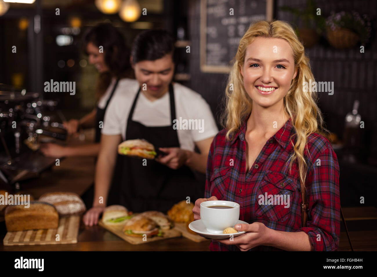 Smiling blonde customer in front of the counter Stock Photo - Alamy