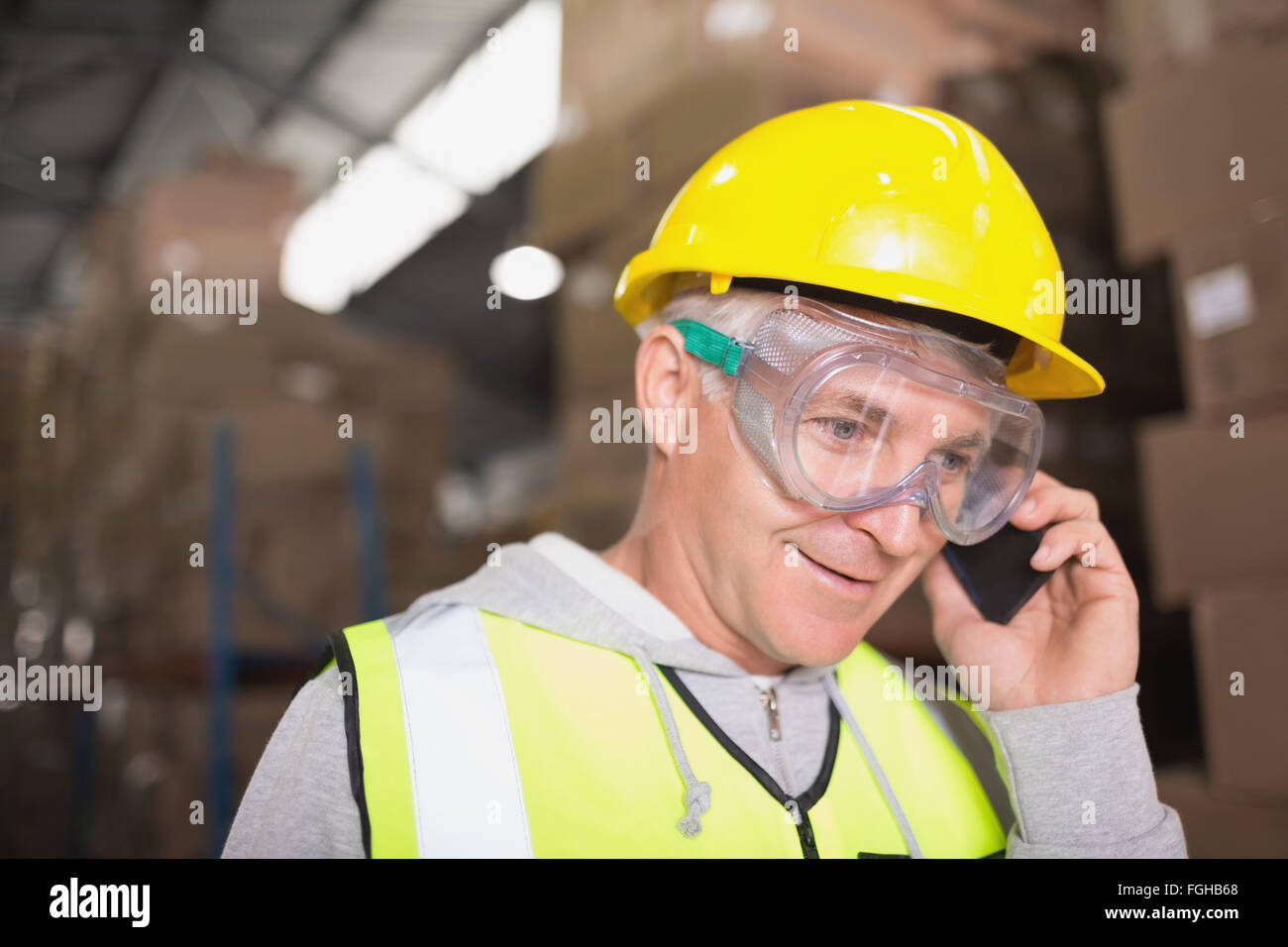 Worker using mobile phone in warehouse Stock Photo - Alamy