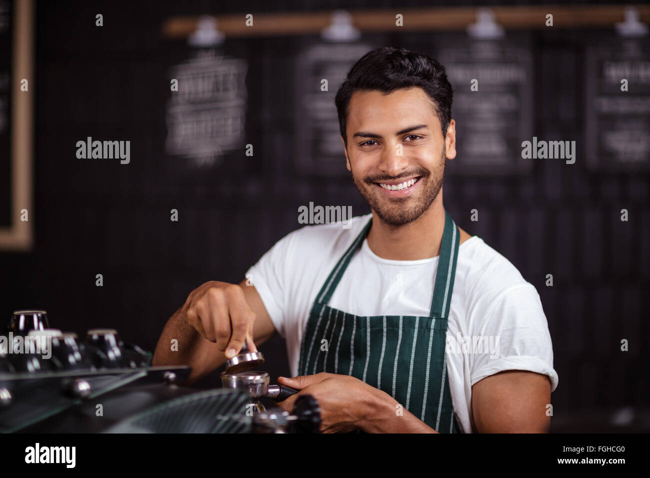 Smiling barista preparing coffee with a machine Stock Photo - Alamy