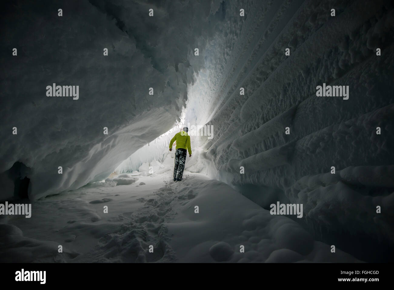 A man explores inside an ice cave in the Erebus Glacier, Antarctica ...