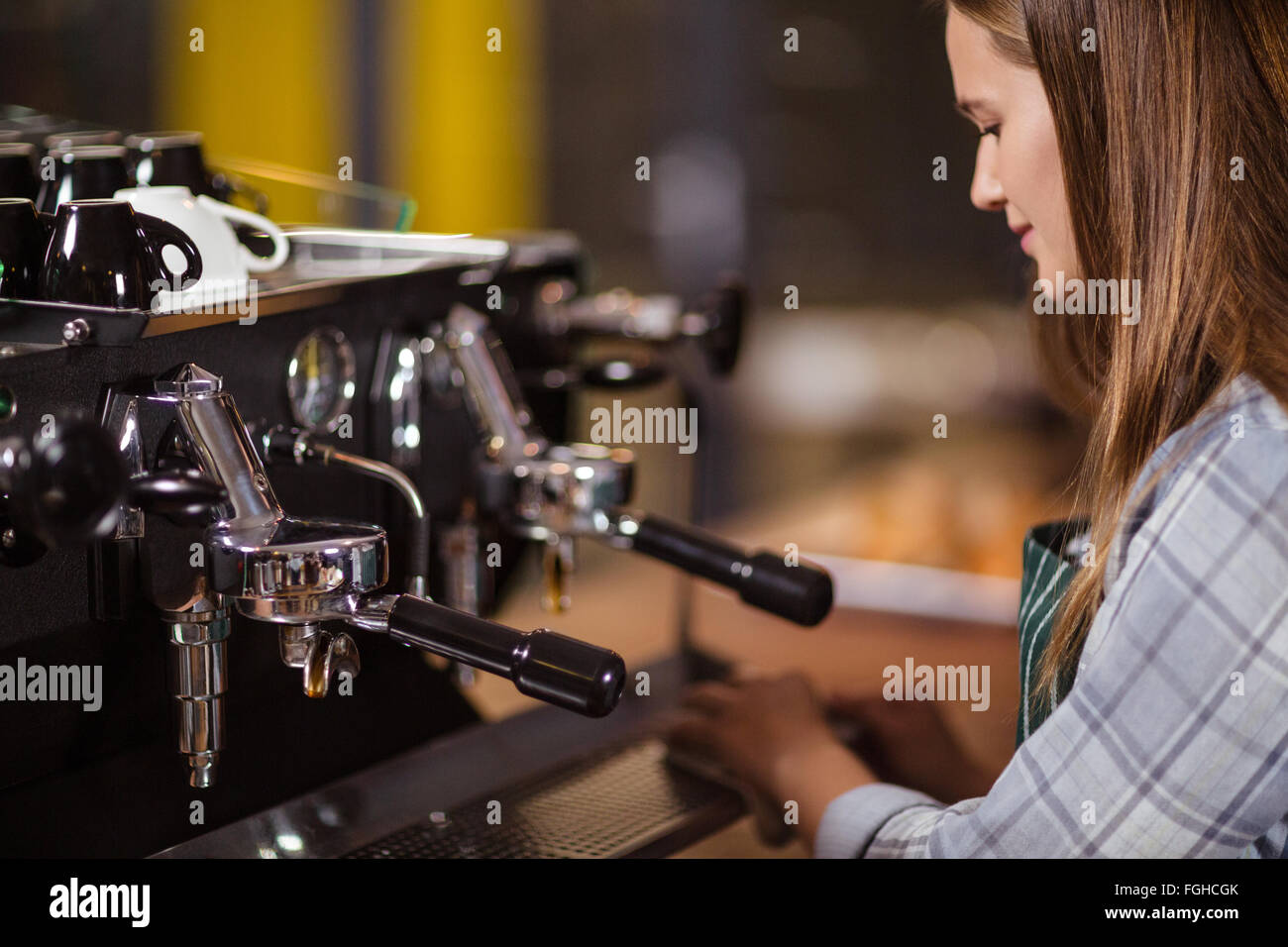 Smiling barista cleaning coffee machine Stock Photo - Alamy