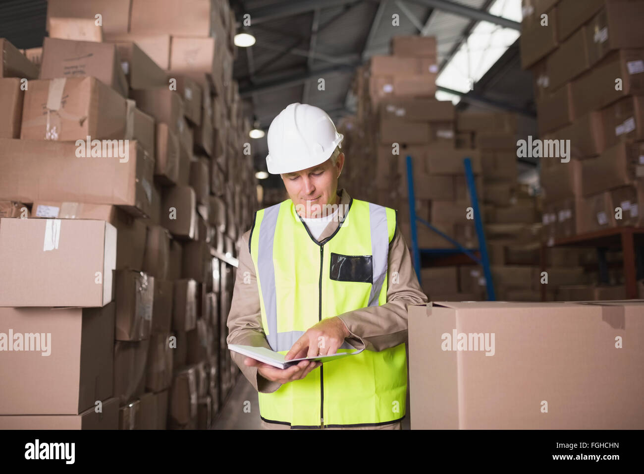Worker with diary in warehouse Stock Photo - Alamy