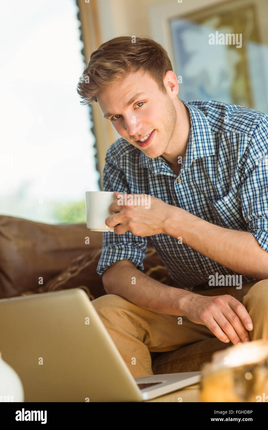 Young man using laptop on his couch Stock Photo - Alamy