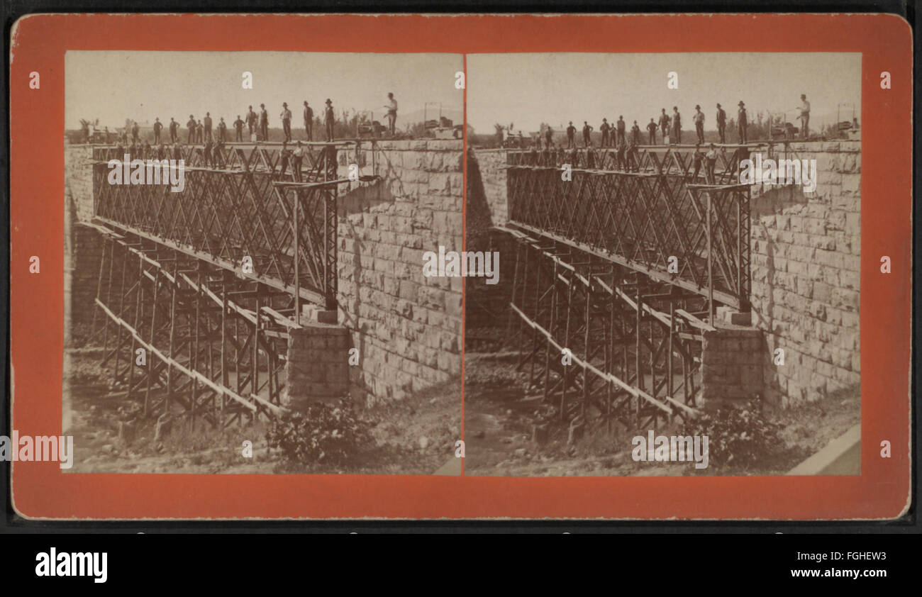 This photograph by E.M. Johnson shows a bridge under construction ...