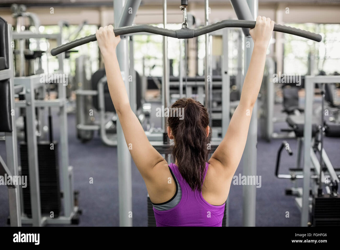 Fit woman using weight machine Stock Photo - Alamy