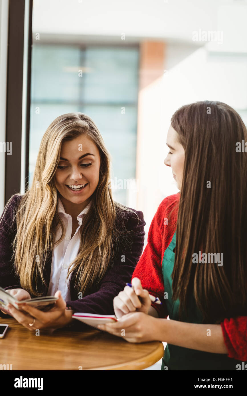 Cute blonde girl ordering from her friend Stock Photo - Alamy