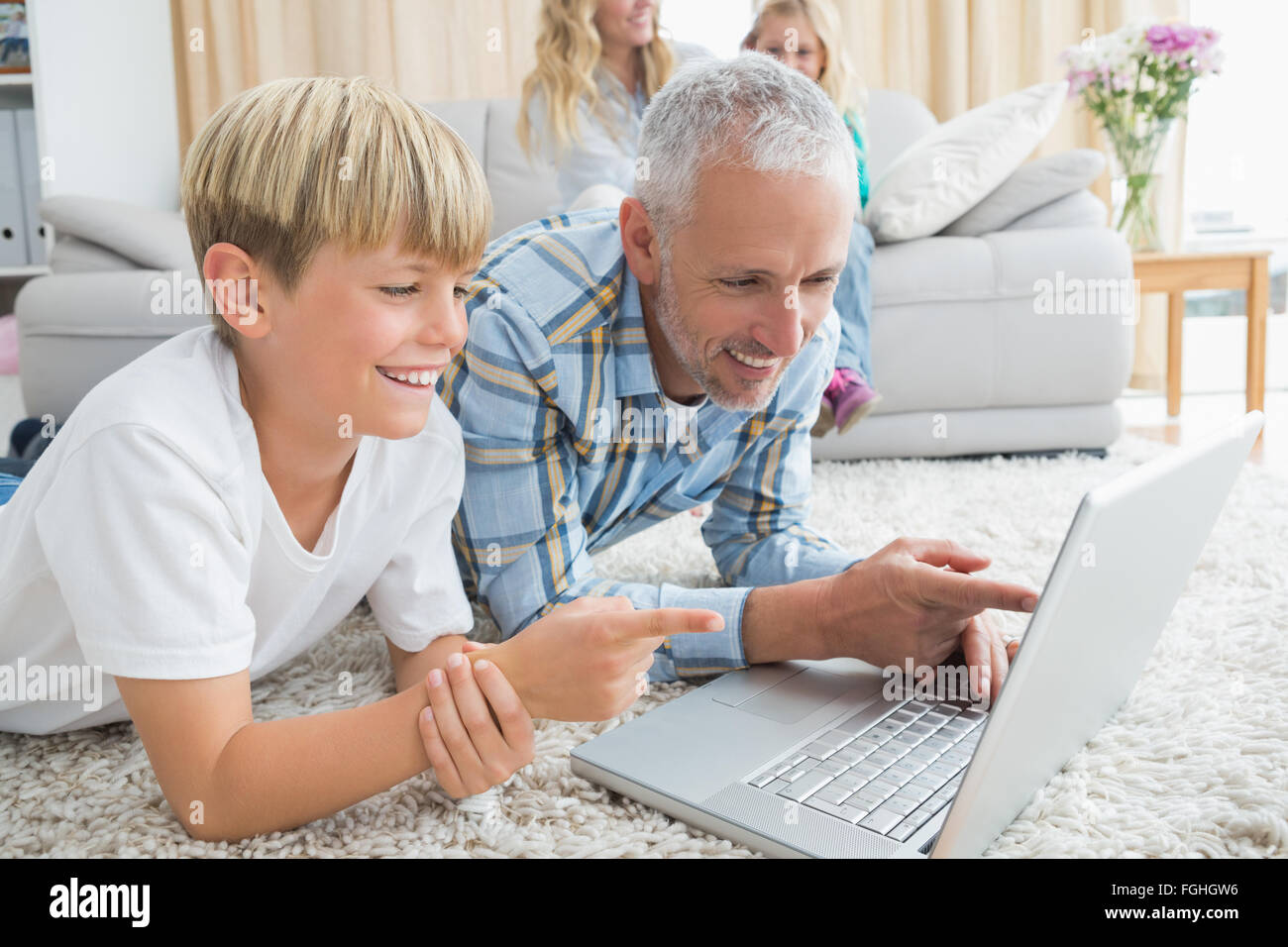 Father and son using laptop on the floor Stock Photo - Alamy
