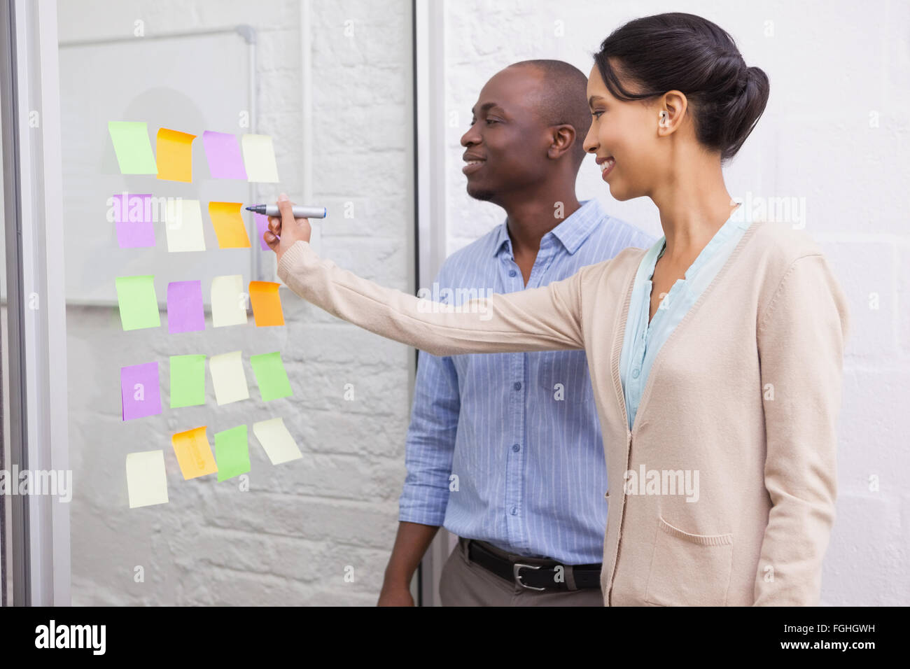 Creative businesswoman writing on sticky notes on window Stock Photo ...