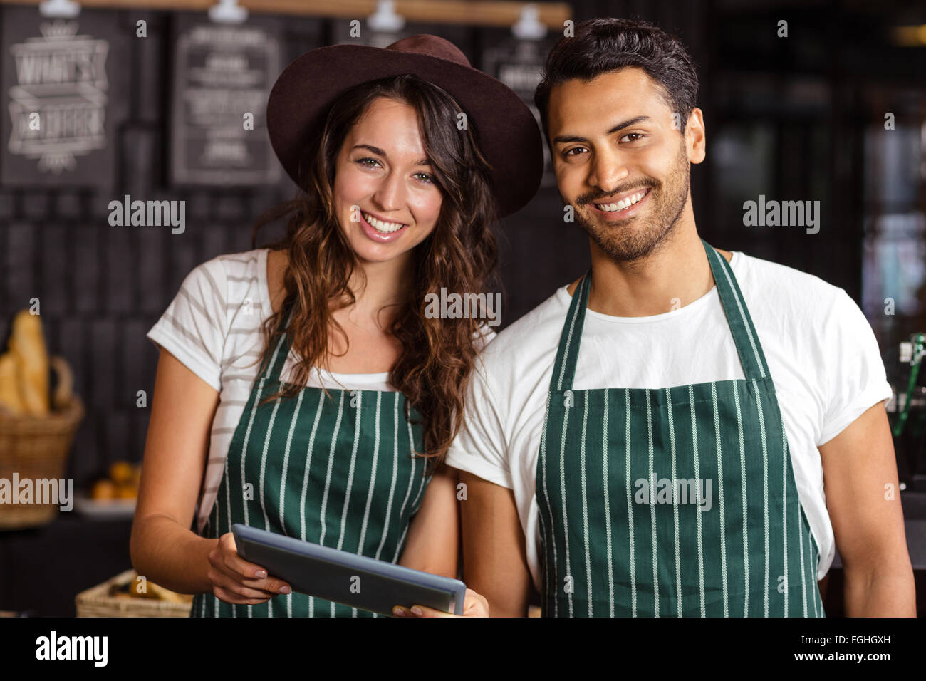 Smiling baristas using tablet Stock Photo - Alamy