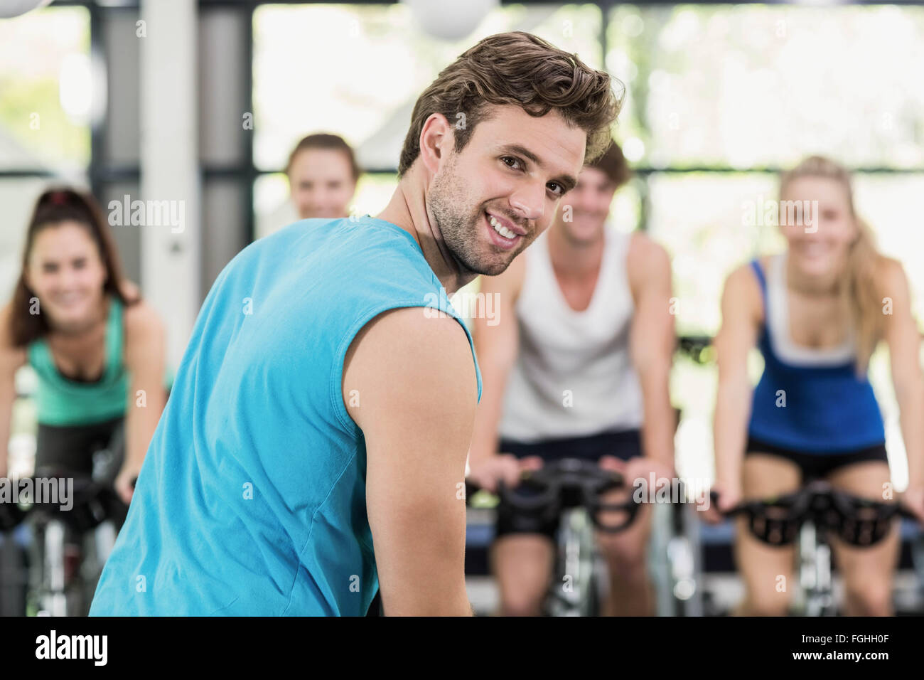 Fit group of people using exercise bike together Stock Photo - Alamy