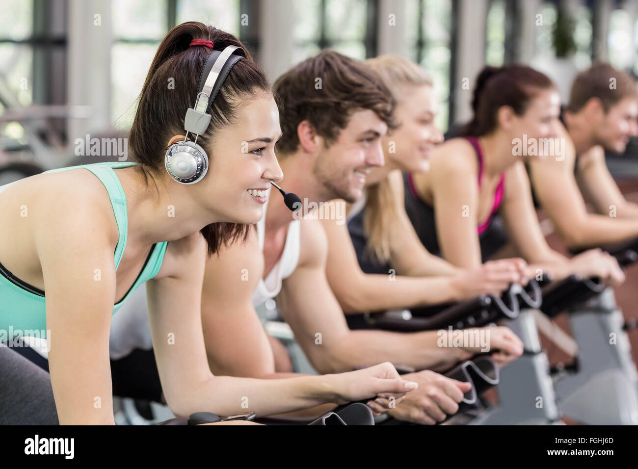 Fit group of people using exercise bike together Stock Photo - Alamy