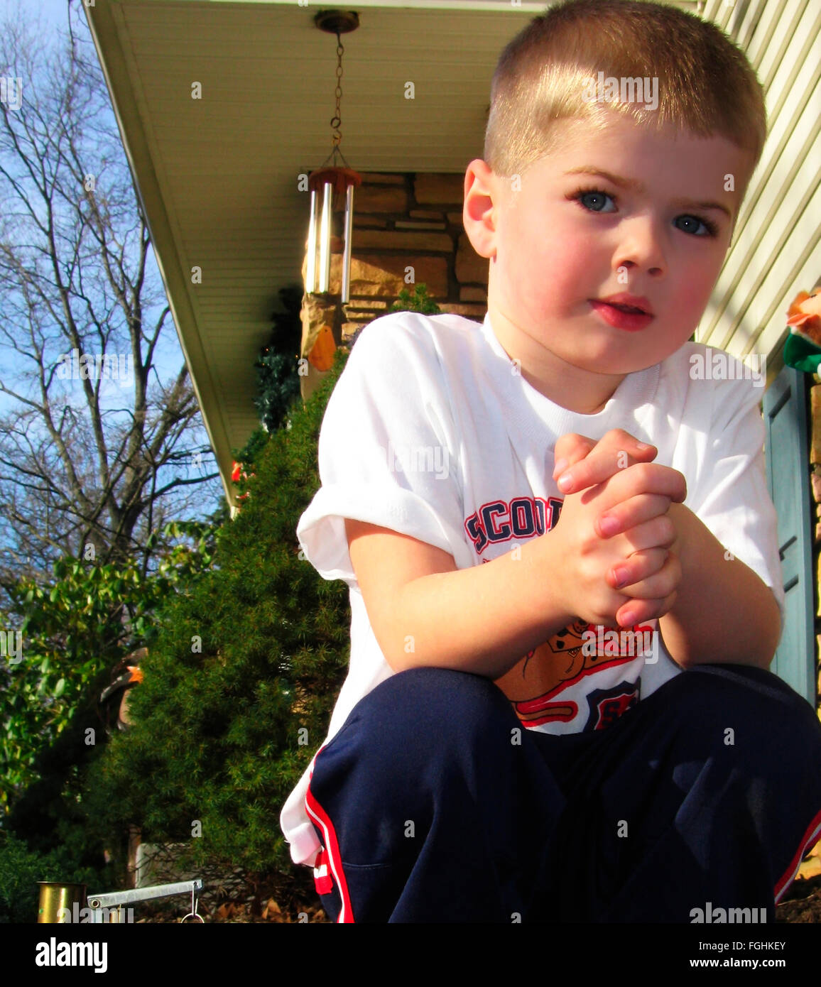 little boy sitting with hands folded Stock Photo - Alamy