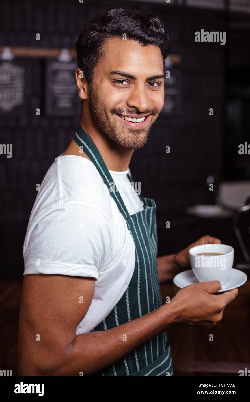 Smiling barista holding coffee Stock Photo - Alamy
